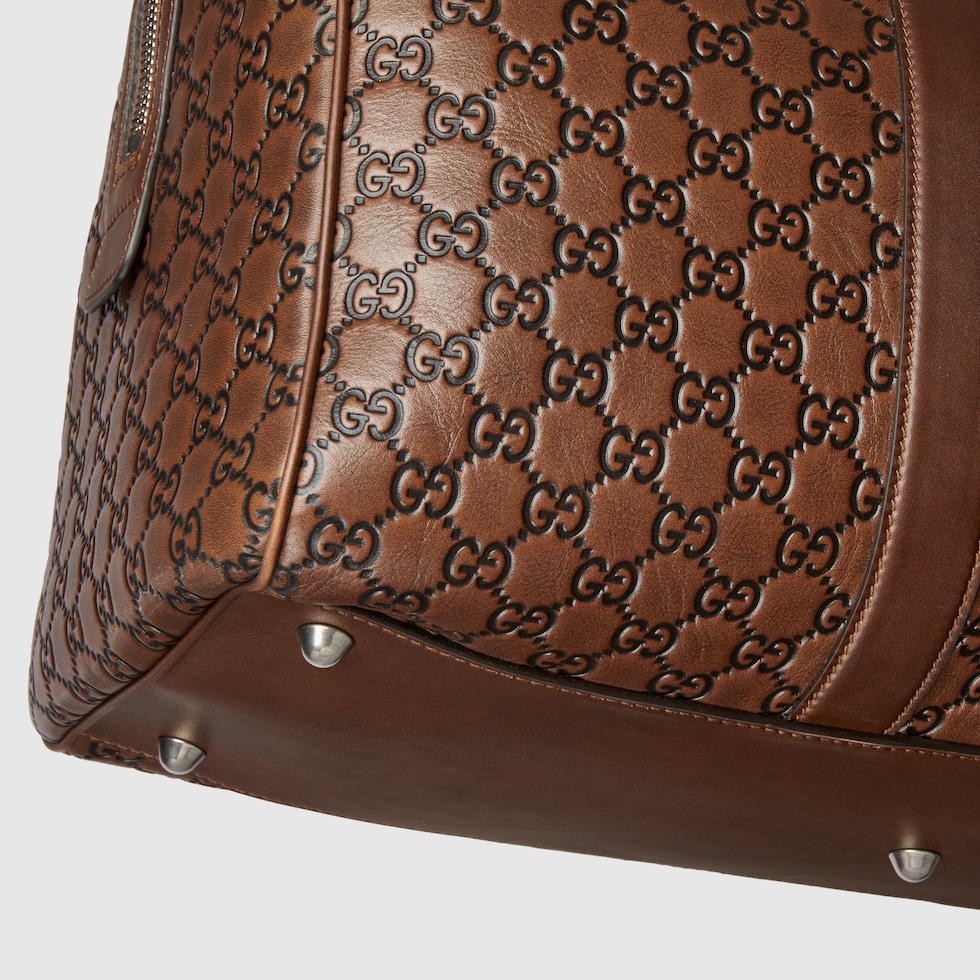 GG Emblem medium duffle bag in brown and black GG leather | GUCCI® US